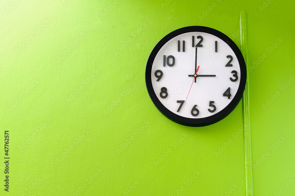 Clock showing 3 o'clock pm on a green wall Stock Photo | Adobe Stock