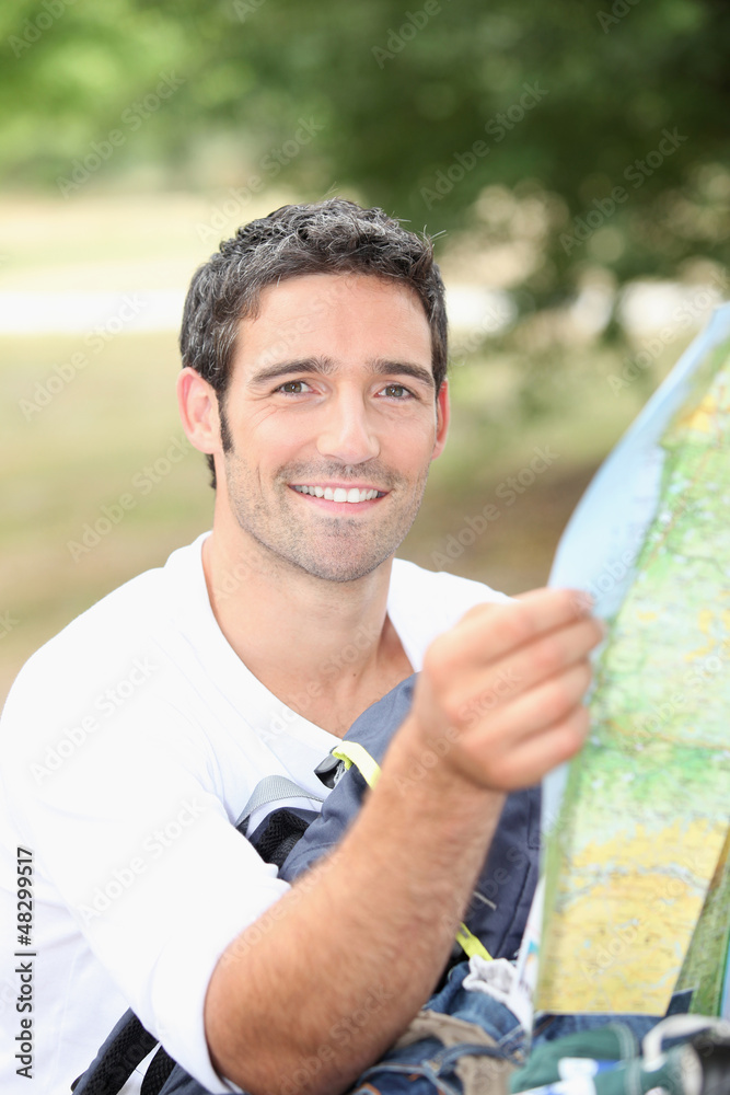 30 years old man watching a map in the forest Stock Photo | Adobe Stock