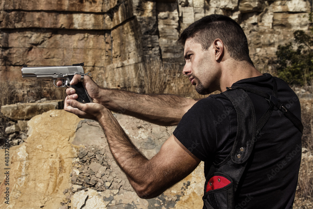 menacing man pointing a handgun Stock Photo | Adobe Stock