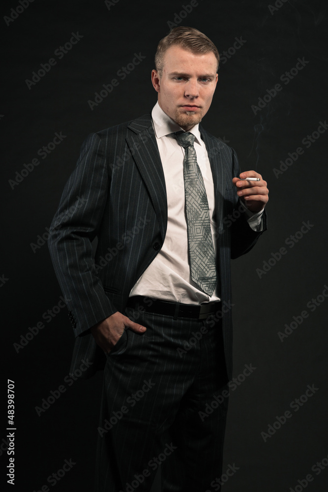 Fashion man in suit smoking cigarette. Studio shot. Stock Photo | Adobe ...