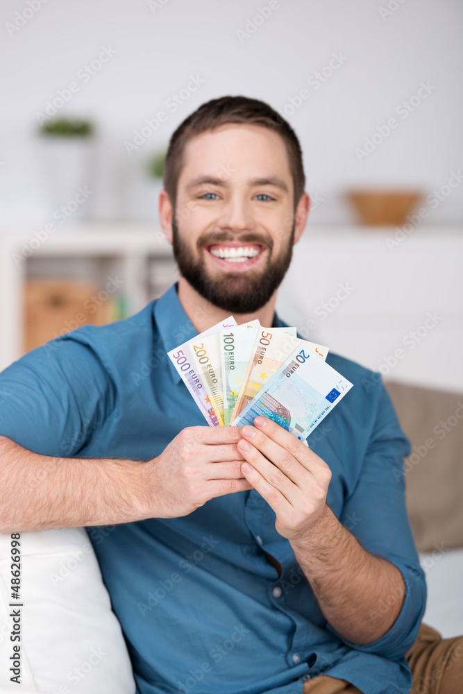 lachender mann zeigt geldscheine Stock Photo | Adobe Stock