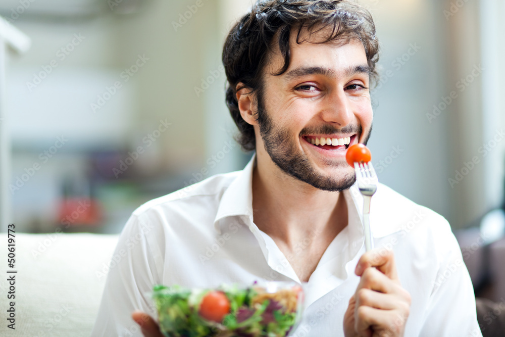 Happy man eating a salad Stock-Foto | Adobe Stock