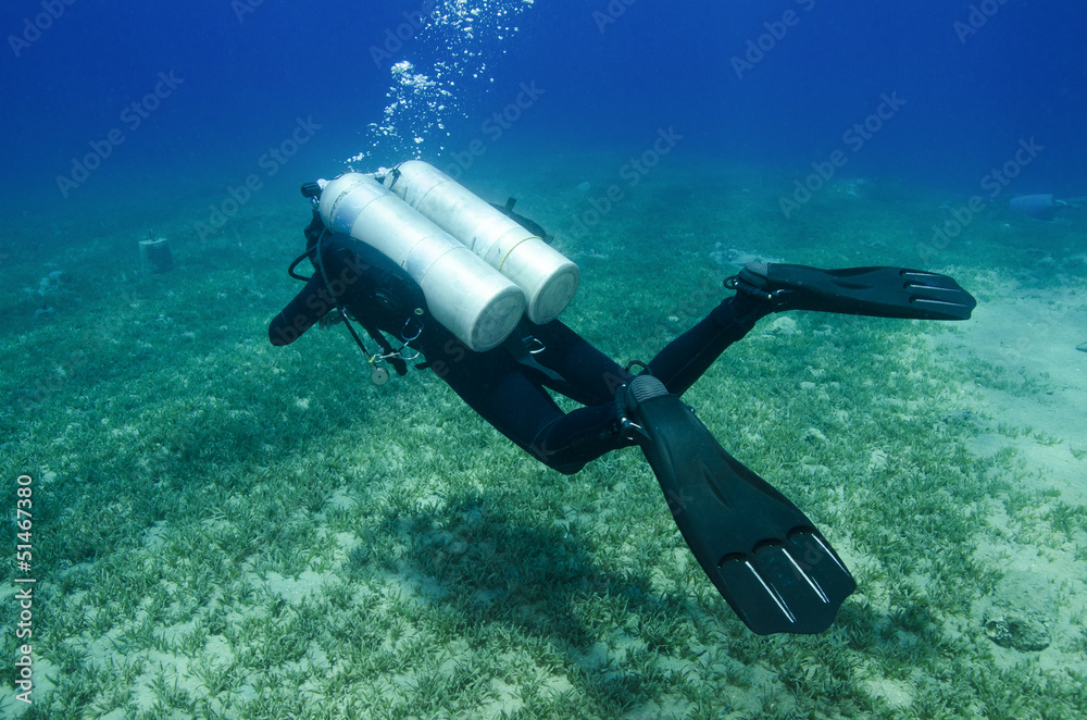 girl scuba dives in clear blue water with twin tanks Stock Photo ...