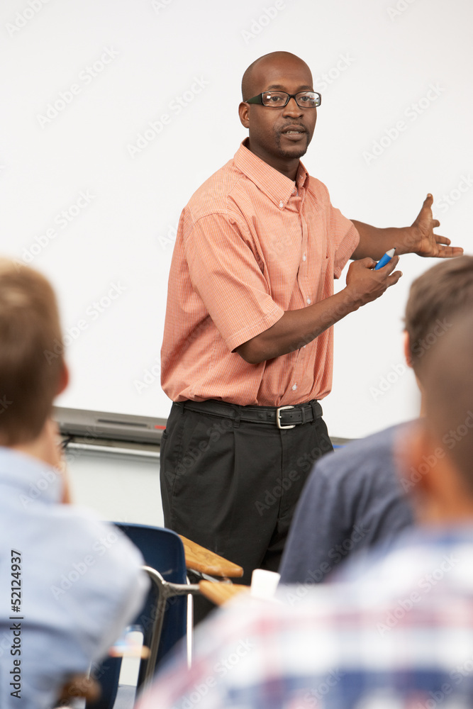 Teacher Talking To Class Standing In Front Of Whiteboard Stock Photo ...
