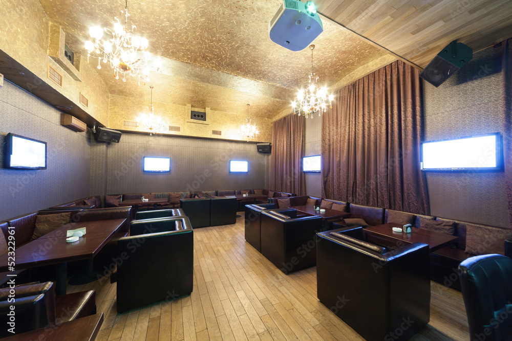 Stylish karaoke bar with armchairs and screens. Stock Photo | Adobe Stock