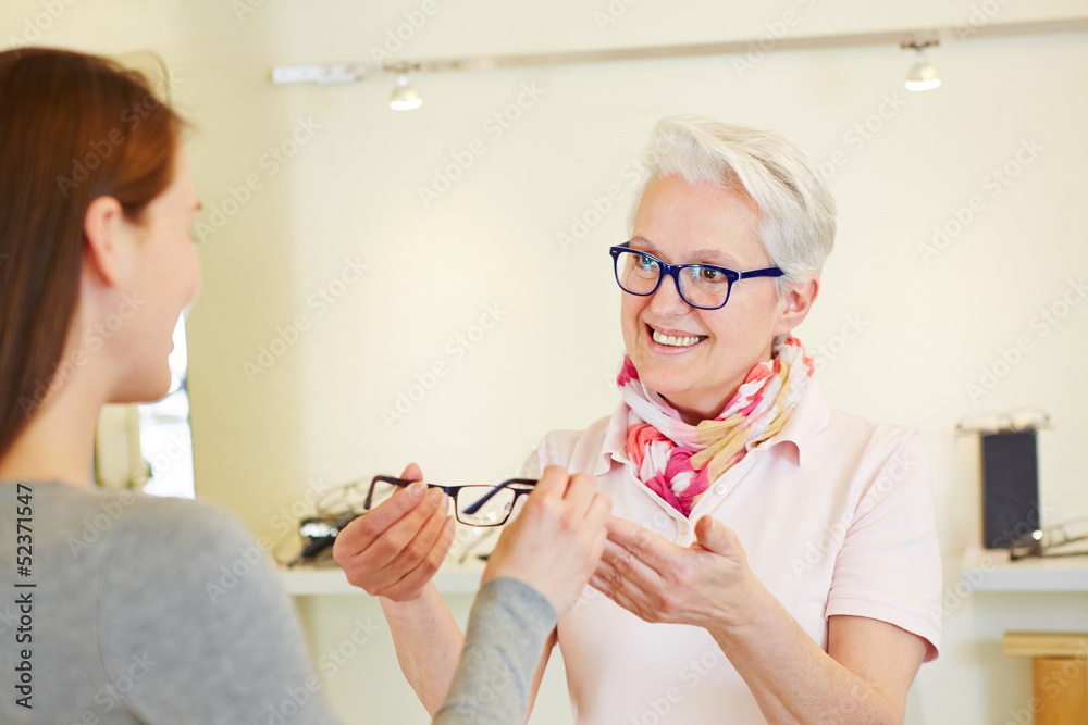 Optiker bietet Frau Brille an Stock Photo | Adobe Stock