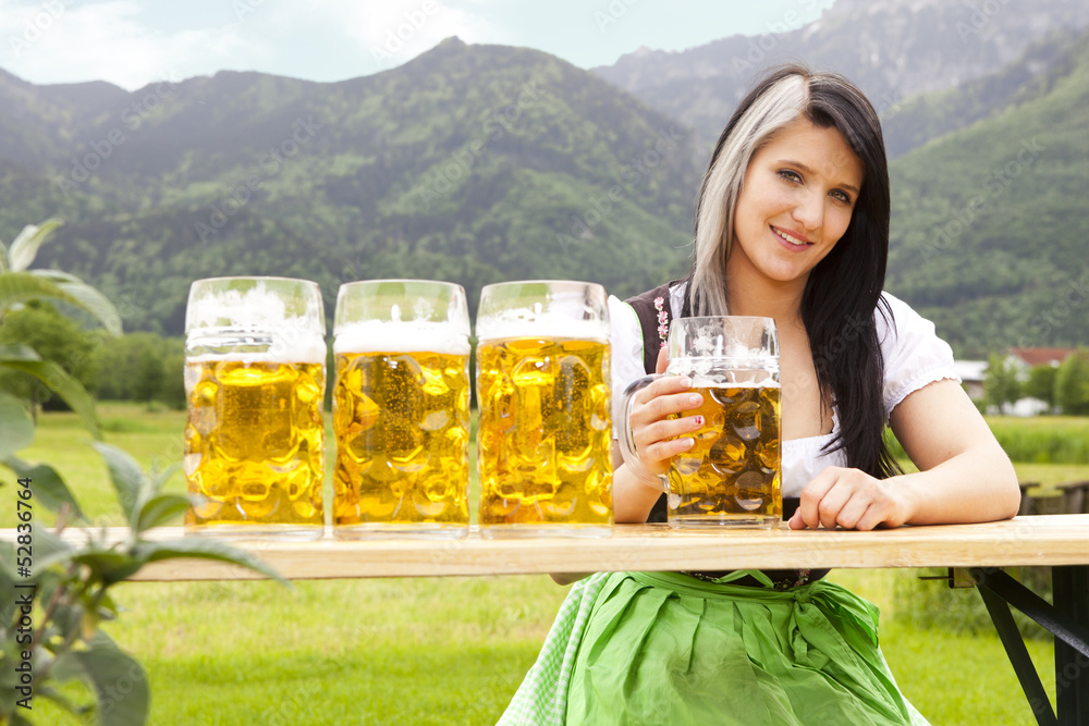 junge Frau im Dirndl in den Bergen mit Maß Bier Stock-Foto | Adobe Stock