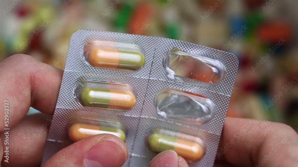 Hand pressing pills out of blister package Stock Video | Adobe Stock