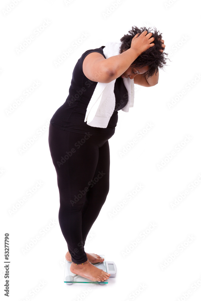 Disappointed African American woman using a scale - African peo Stock ...