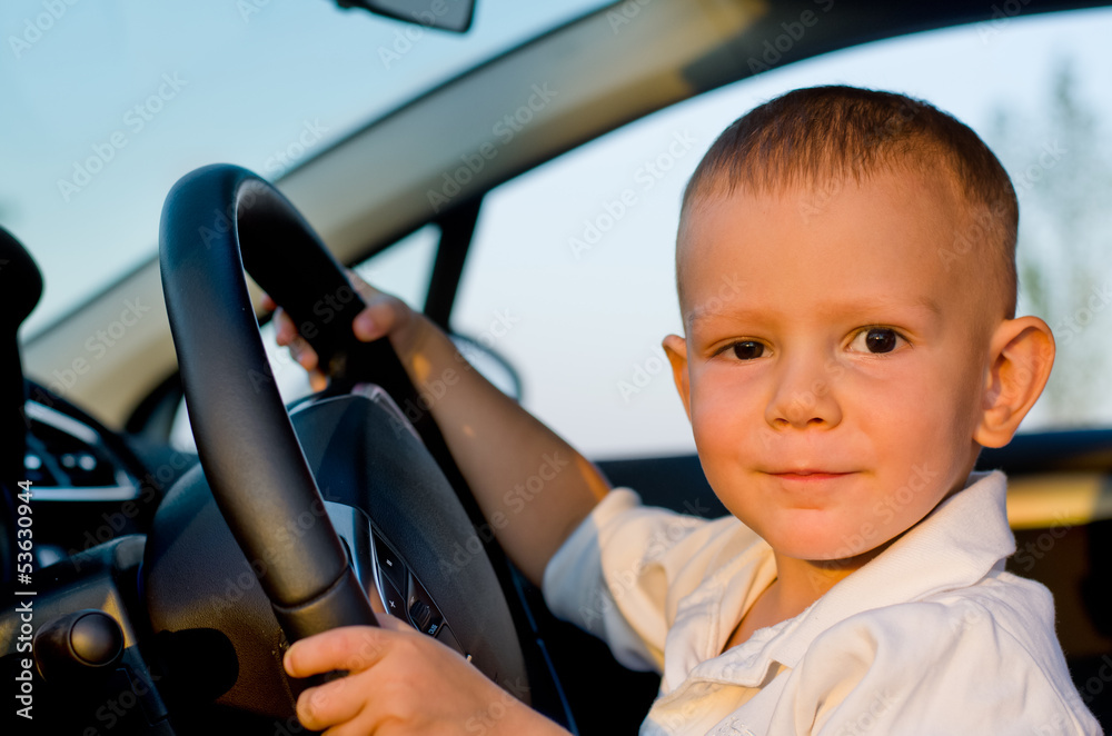 Little boy sitting behind the wheel of a car Stock Photo | Adobe Stock