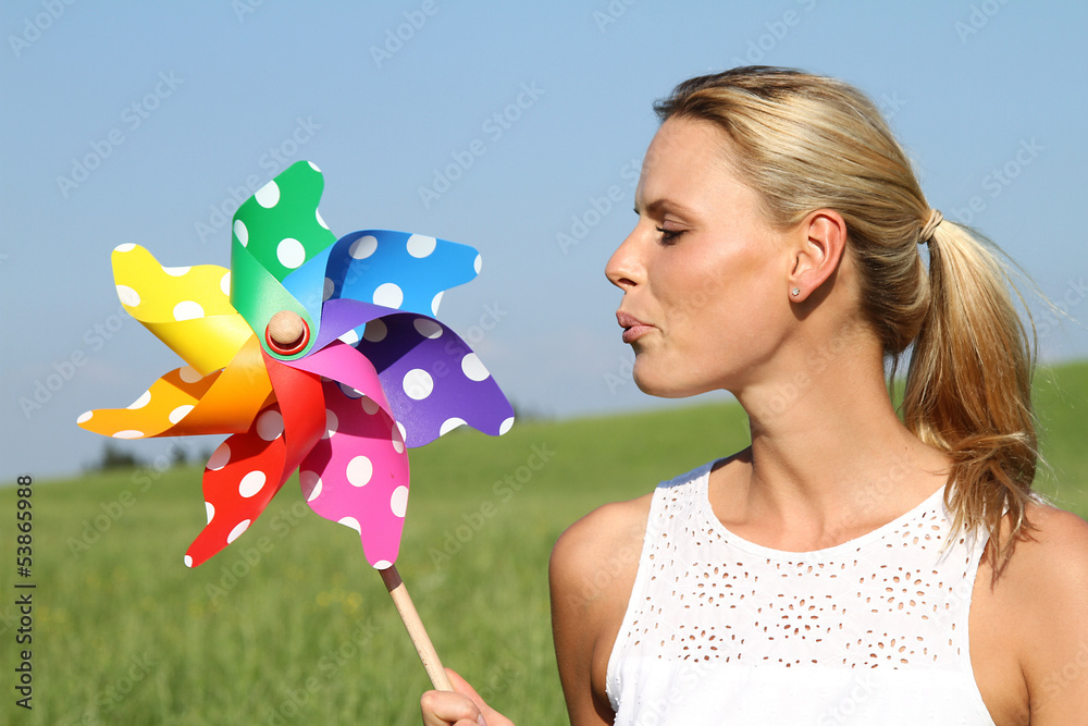 Frau pustet Windrad Stock Photo | Adobe Stock