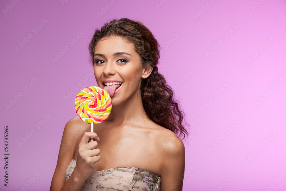 Eating a lollipop. Beautiful young women eating lollipop while s Stock ...