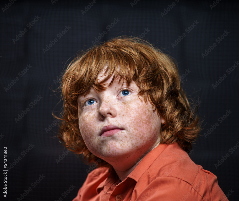 Freckled red-hair boy posing on dark background. Stock Photo | Adobe Stock