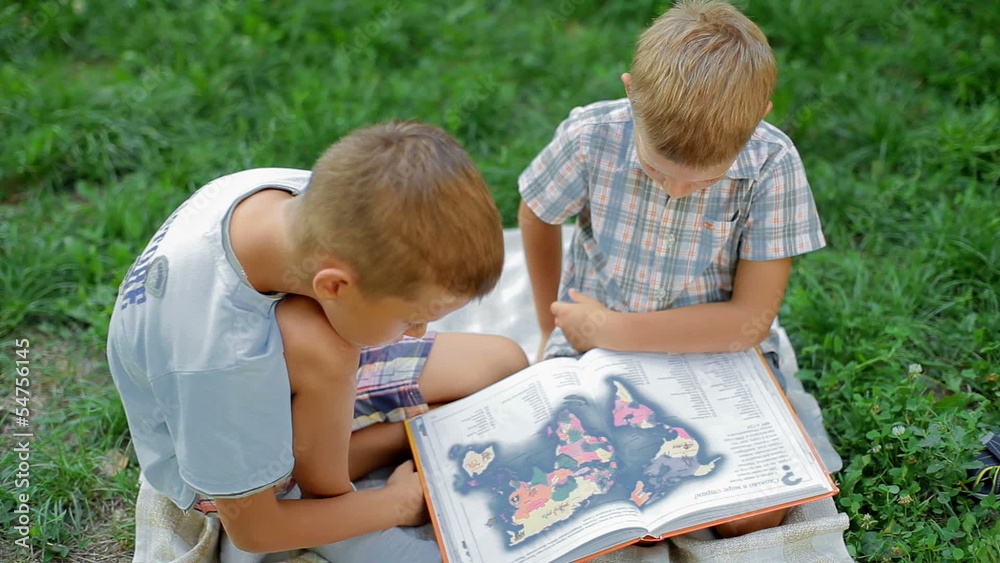 Two young boys studying in the encyclopedia map of the world Stock ビデオ ...
