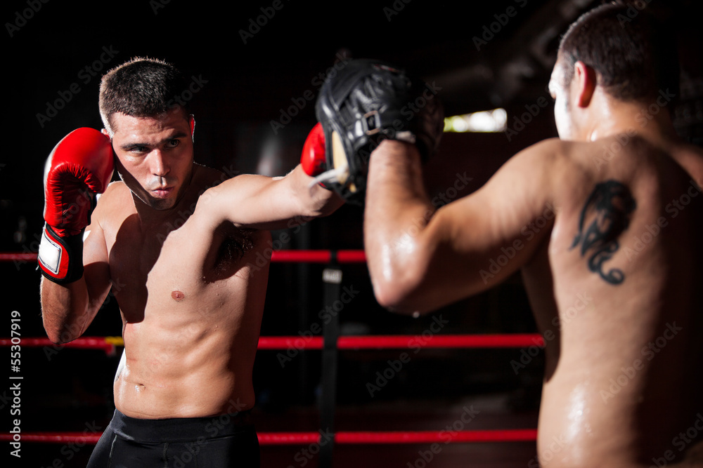 Latin boxer and his coach doing some sparring in the ring Stock 写真 ...