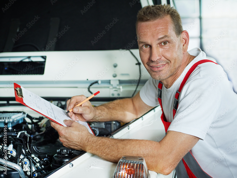 Motor mechanic in front of engine bay is checking repair details Stock ...