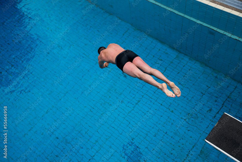 Man jumps from diving board at swimming pool Stock Photo | Adobe Stock