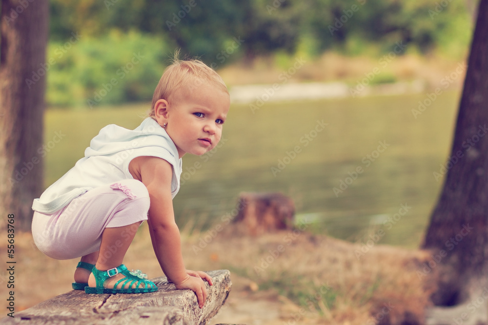 Little girl crouching on the bench Stock Photo | Adobe Stock