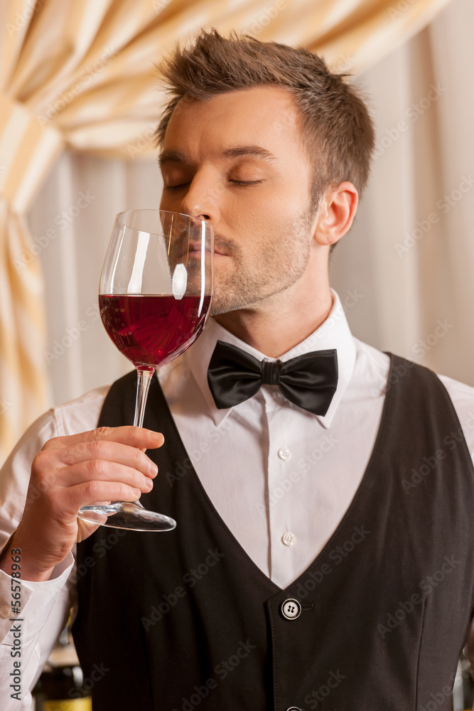 Confident sommelier. Handsome young sommelier holding a wine gla Stock ...