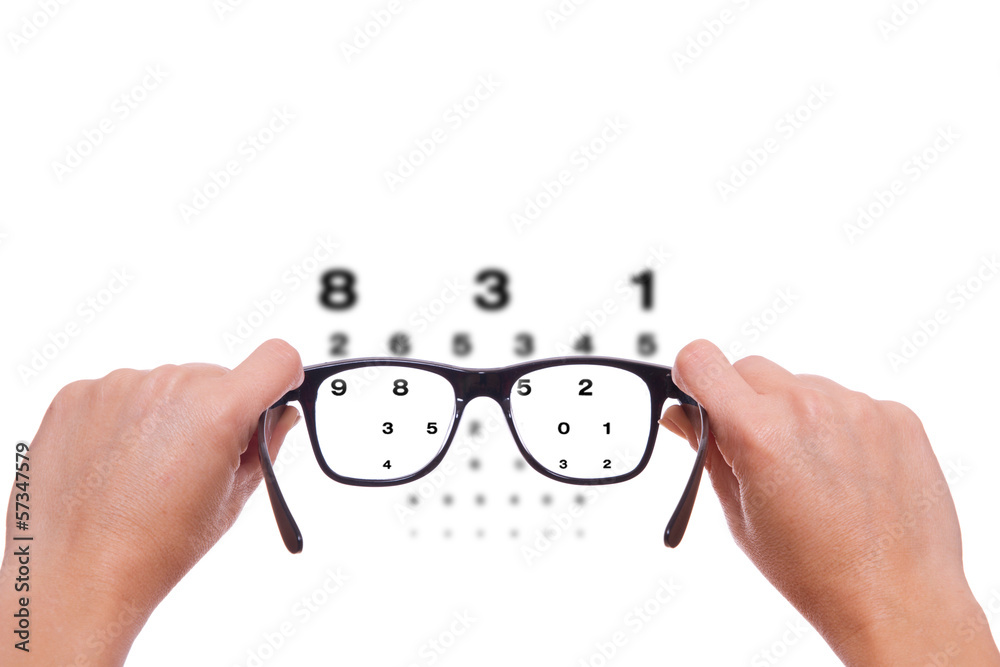 zwei Hände halten eine Brille beim Sehtest Stock Photo | Adobe Stock
