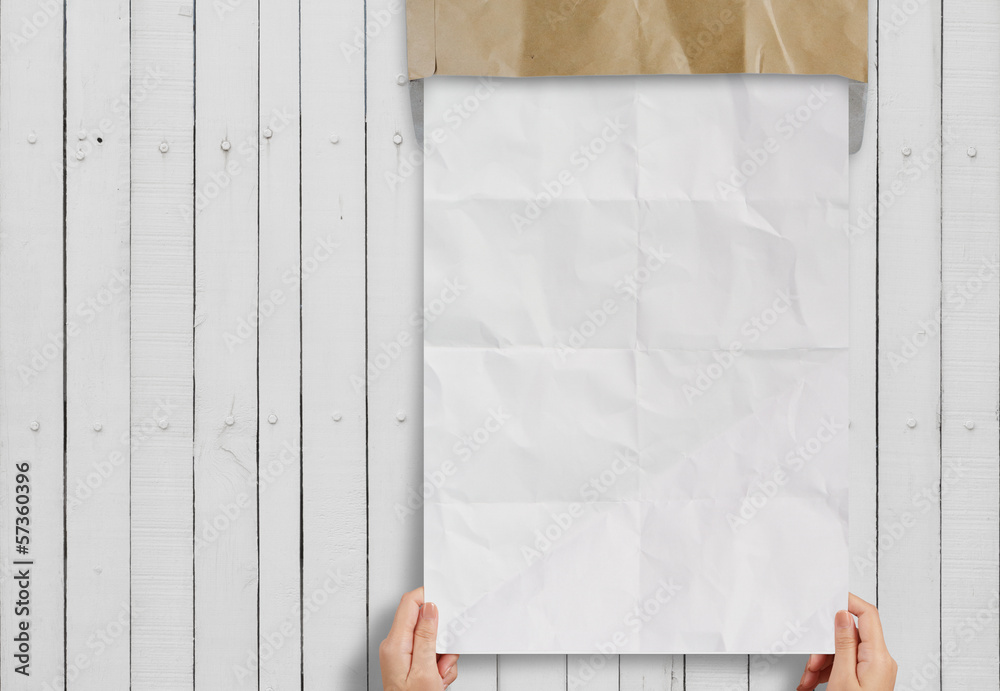 hand pulling crumpled paper from recycle envelope on white wood Stock ...