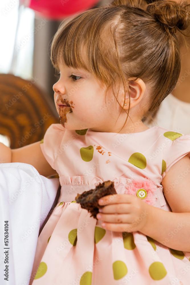 Girl Eating Cake With Icing On Her Face Stock Photo | Adobe Stock