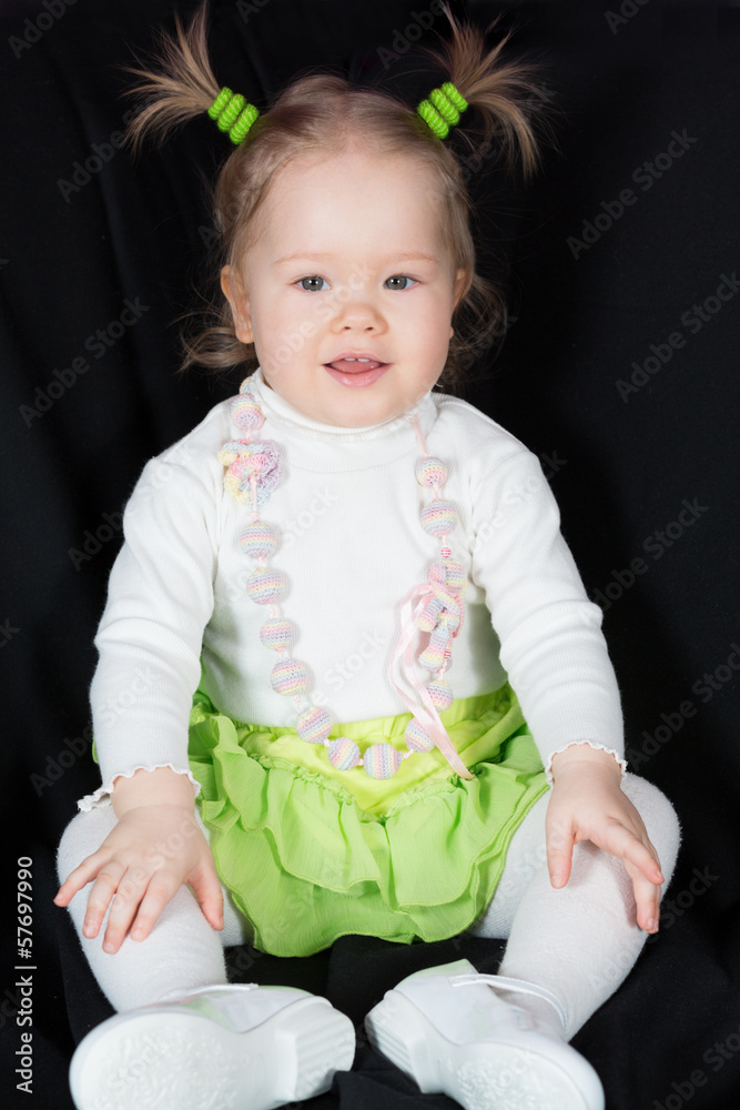 Little girl in a green skirt with funny scrunchy on the head Stock ...