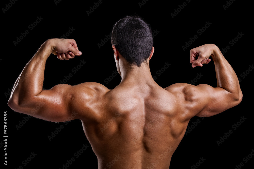 Muscle young man showing his back muscles against a dark backgro Stock ...