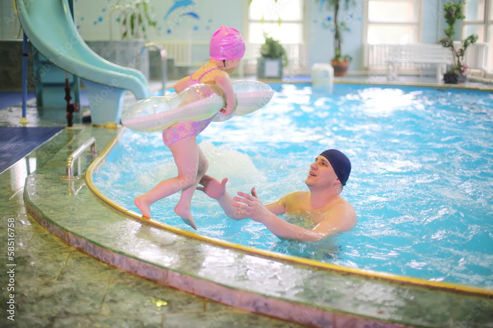 Little girl jumping with an inflatable round tube in pool Stock Photo ...