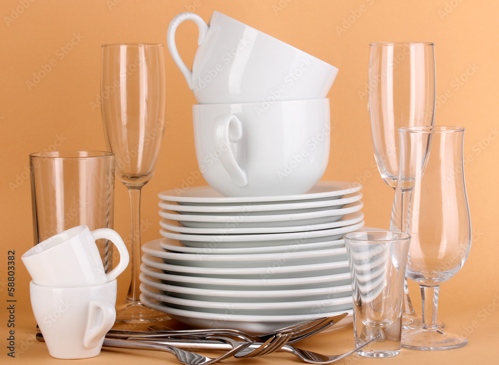 Clean white dishes on beige background Stock Photo | Adobe Stock