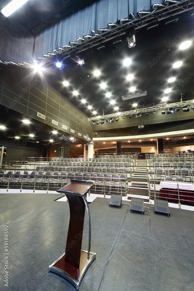 Foto de Document stand on stage and rows of seats in big black hall do ...