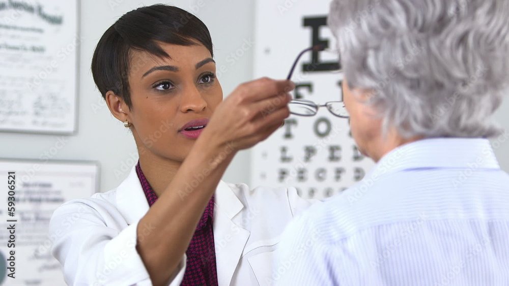 African American optometrist gives eyeglasses to senior woman Stock ...