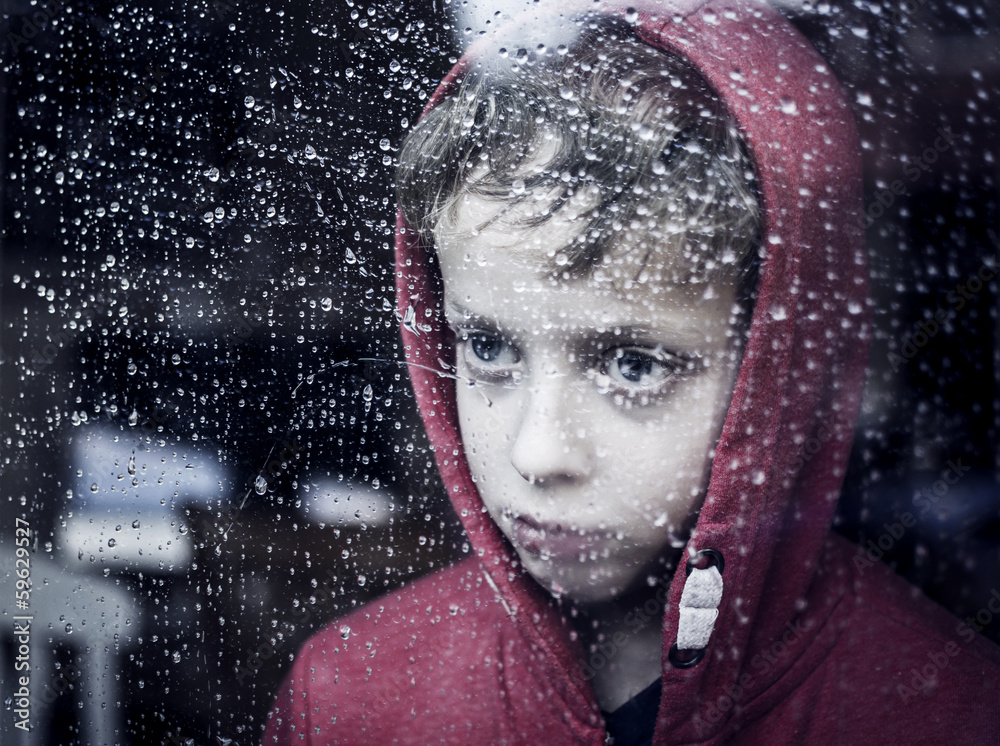 Sad boy looking through window to the rain Stock Photo | Adobe Stock