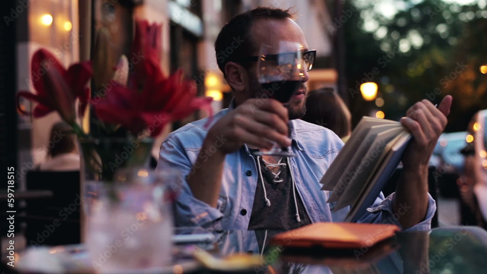 man reading a book and drinking wine in the restaurant Stock Video ...