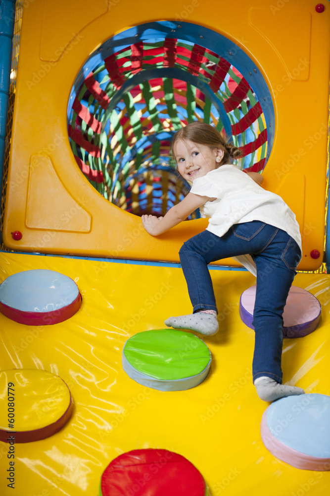 Young girl climbing up ramp into tunnel at soft play centre Stock Photo ...