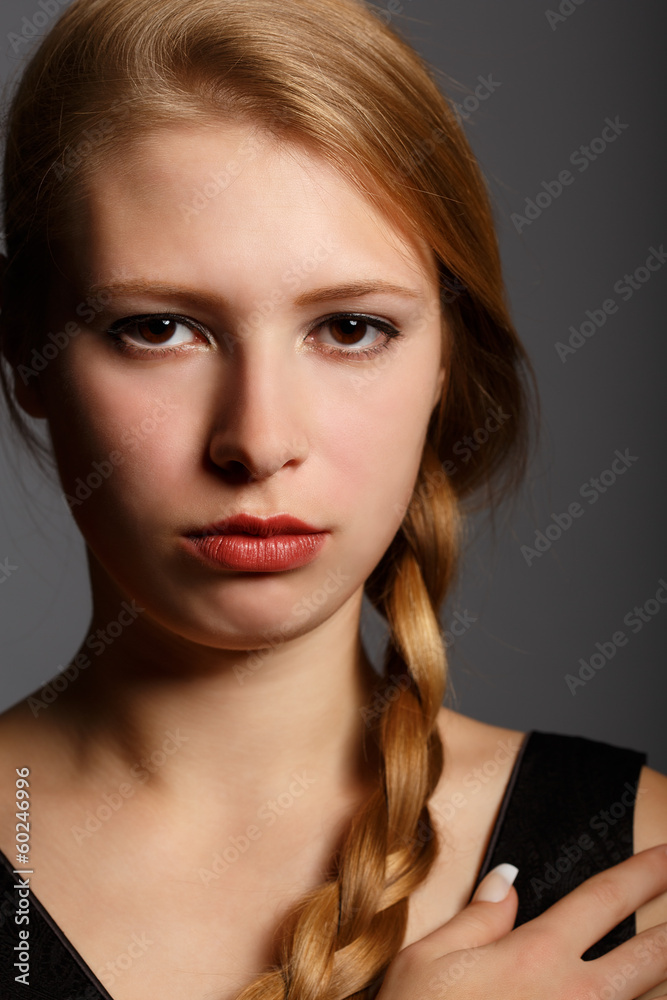 Beautiful young woman with stern look and plait hairstyle Stock Photo ...