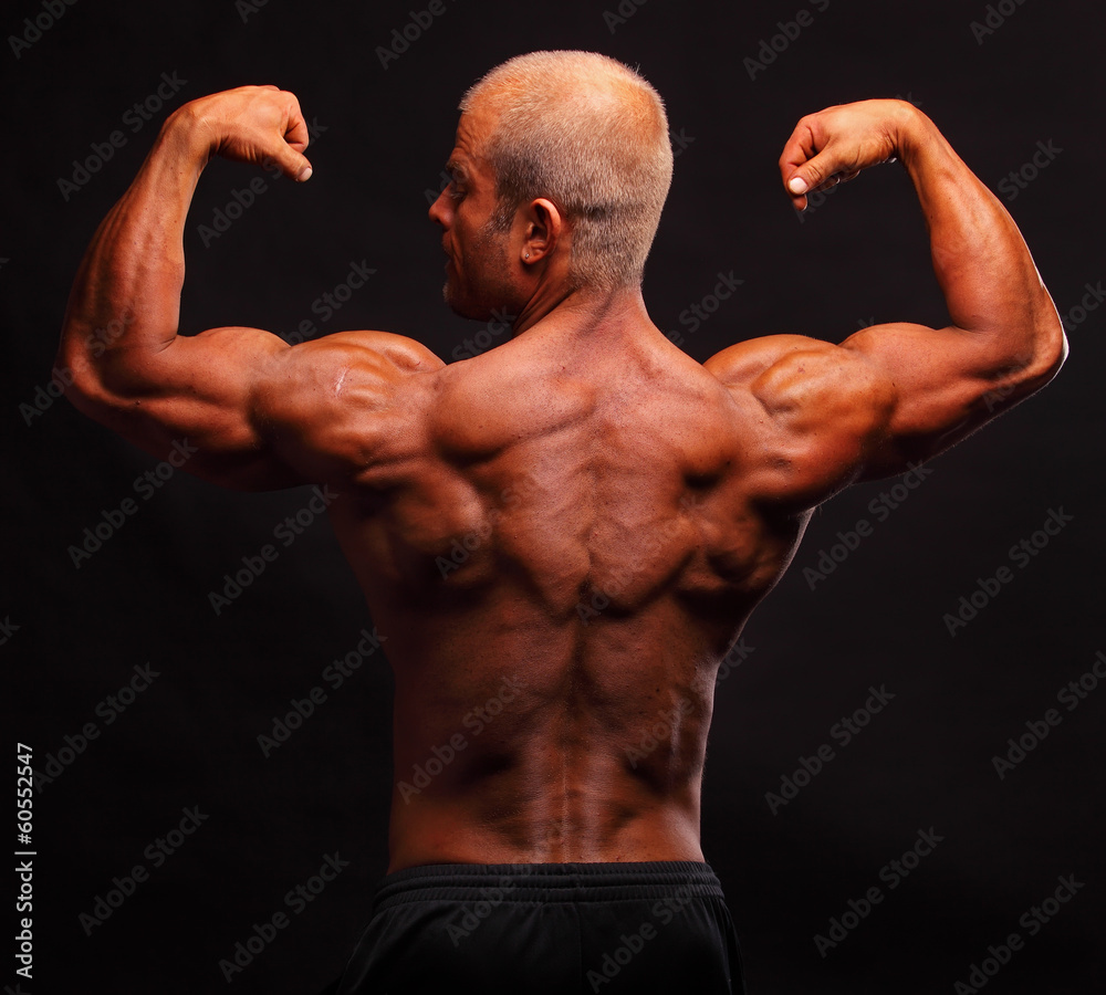 Muscular bodybuilder flexing biceps Stock Photo | Adobe Stock