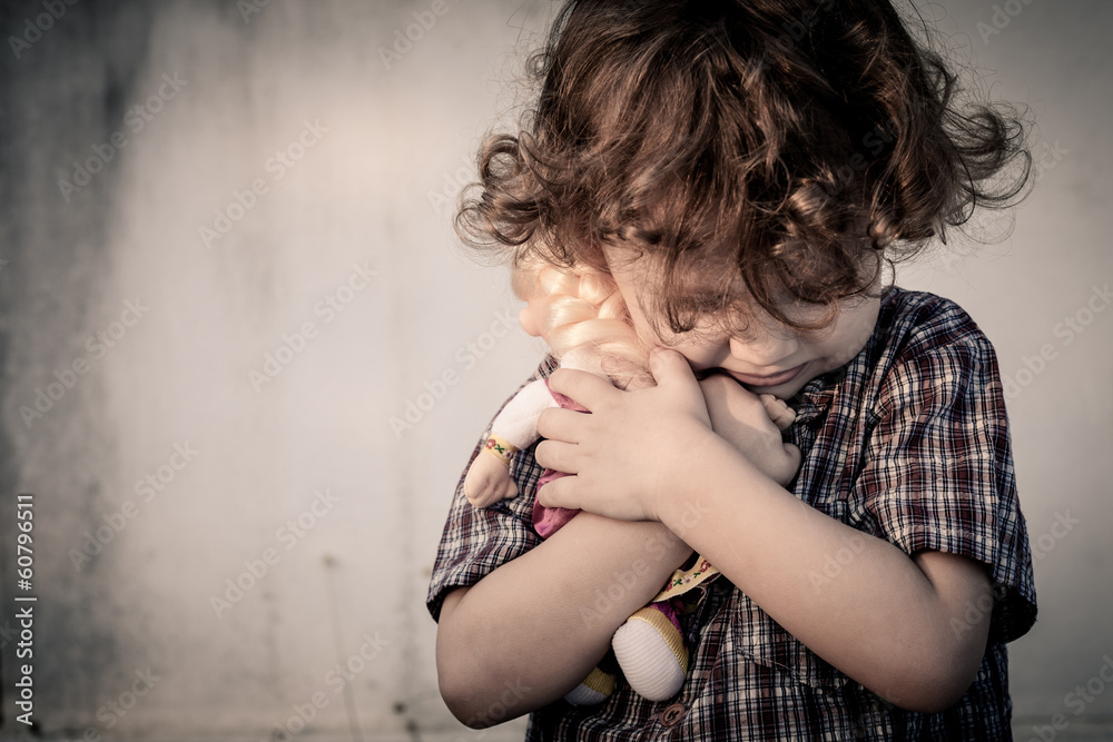 sad little boy hugging a doll Stock Photo | Adobe Stock