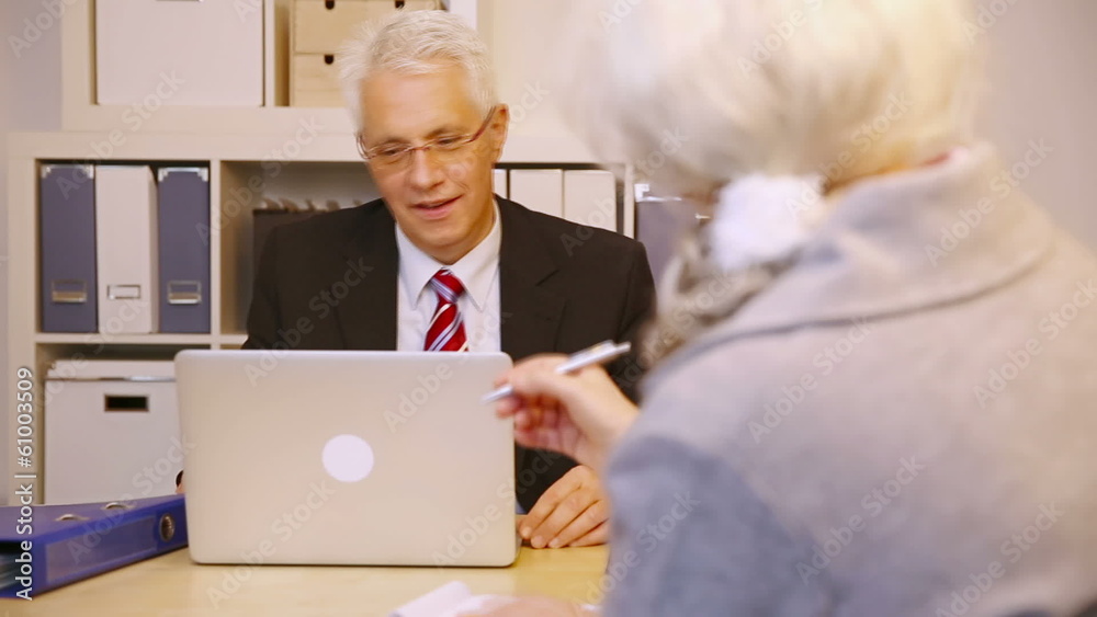 Consultant talking to elderly customer in office Stock Video | Adobe Stock