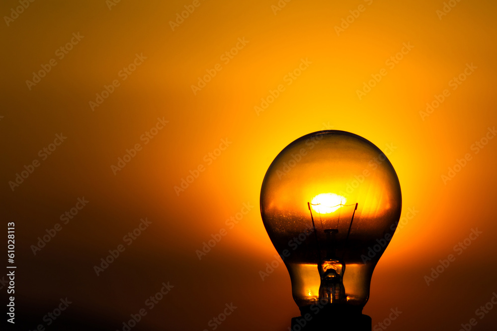 Light bulb with sunset sky background. Stock Photo | Adobe Stock