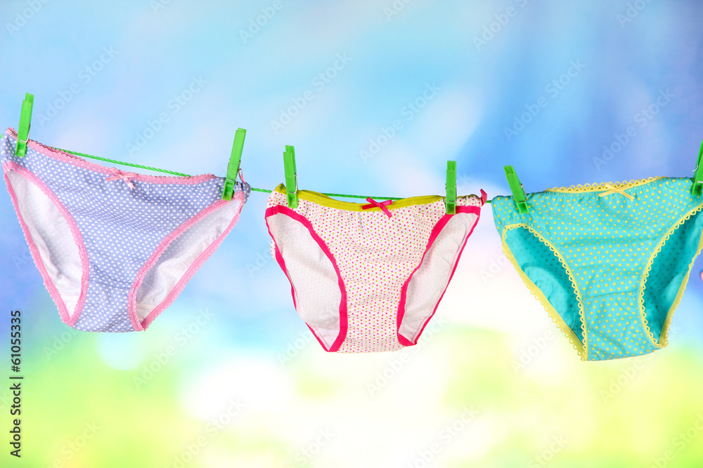 Baby clothes hanging on clothesline, on bright background Stock Photo ...