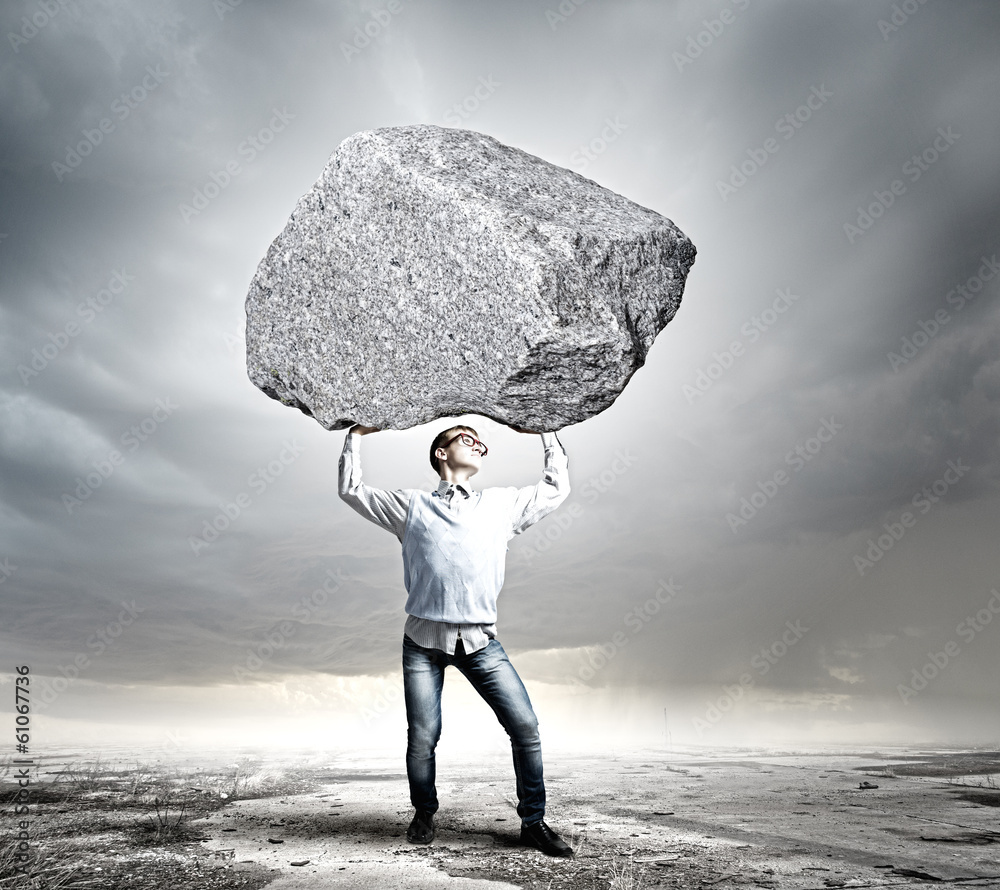 Guy lifting stone Stock Photo | Adobe Stock
