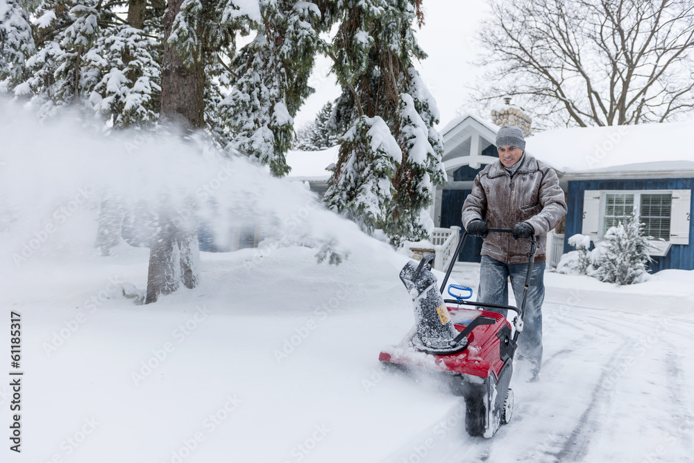 Man clearing driveway with snowblower Stock Photo | Adobe Stock Man clearing driveway with snowblower Stock Photo | Adobe Stock
