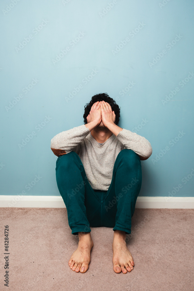 Sad man sitting on the floor Stock Photo | Adobe Stock