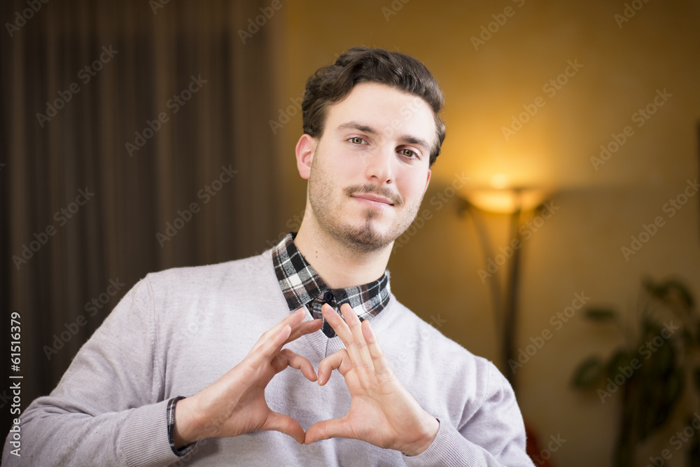 Handsome young man making heart sign with hands Stock Photo | Adobe Stock