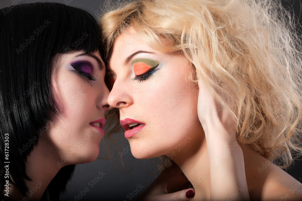 Two young attractive lesbians kissing isolated on gray backgroun Stock Photo | Adobe Stock