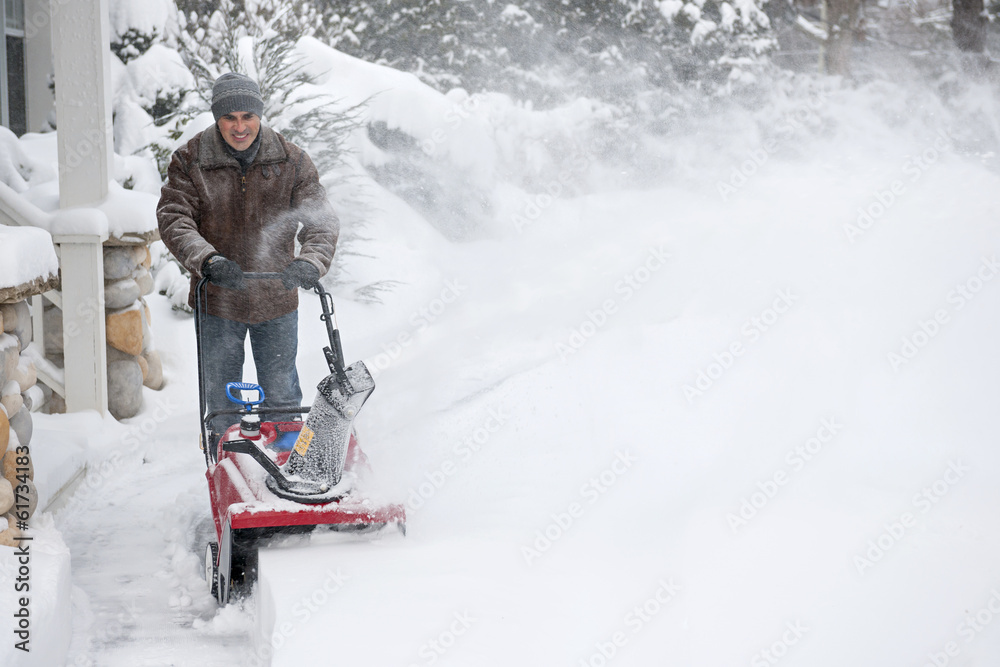 Man clearing driveway with snowblower Stock Photo | Adobe Stock Man clearing driveway with snowblower Stock Photo | Adobe Stock