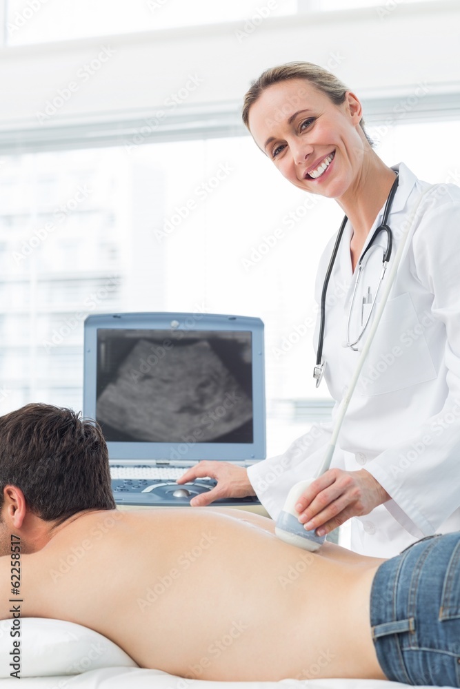 Doctor performing ultrasound scan on back of patient Stock Photo ...