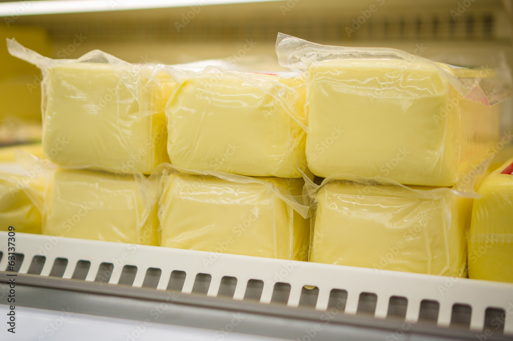 Huge brick form pieces of cheese in color packs on shelves in su Stock ...