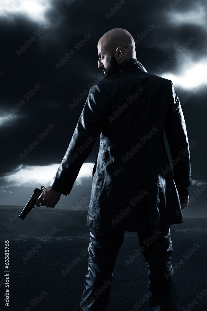 Dangerous bald gangster man with beard holding gun. Wearing blac Stock ...